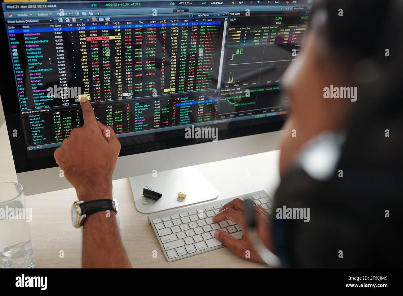 Trader pointing at computer screen with financial data and planning ...