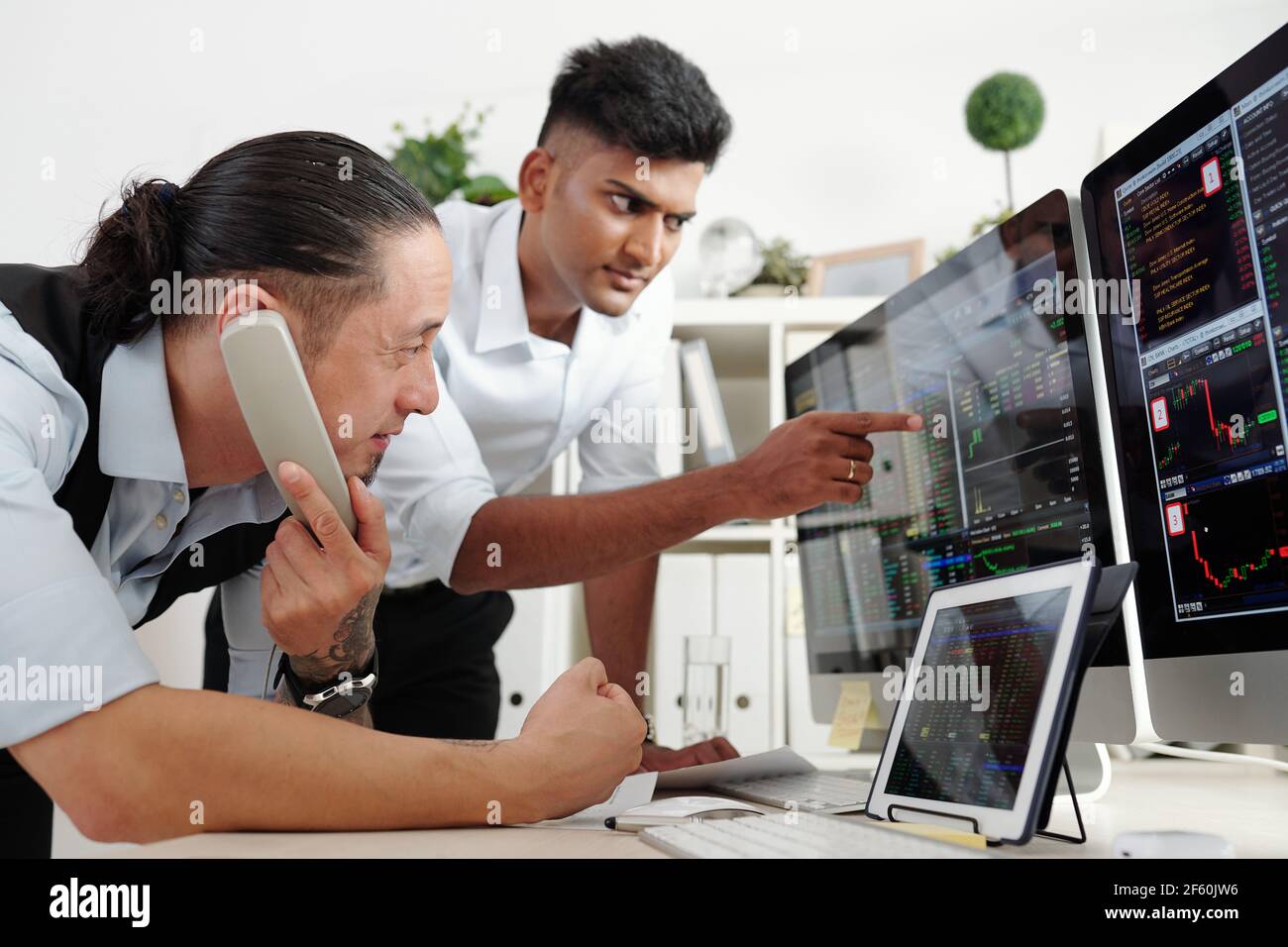 Financial brokers monitoring stock market, analyzing price flow and ...