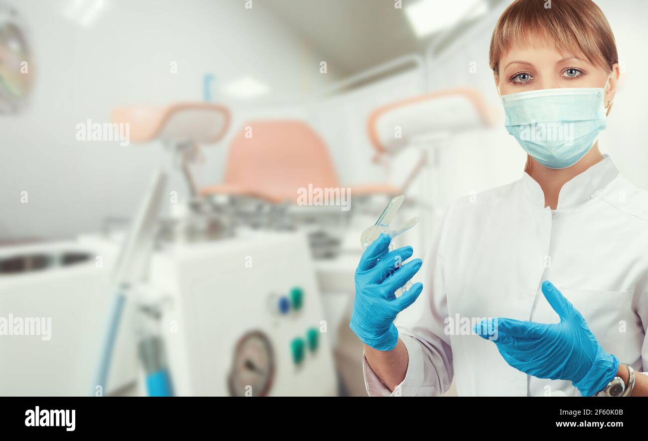 Female gynecologist in protective mask and whitecoat with gynecological ...