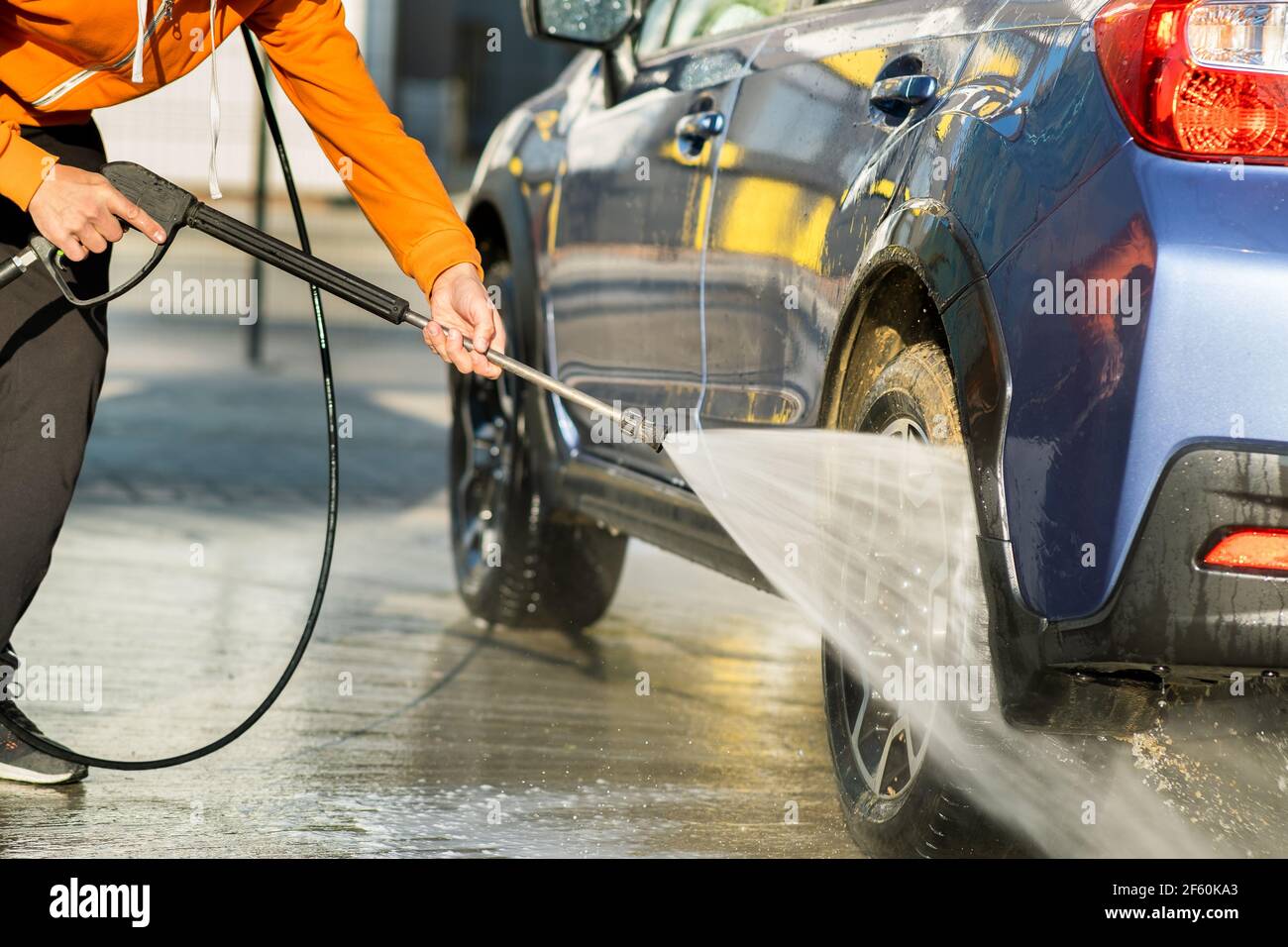 Closeup of male driver washing his car with contactless high pressure ...