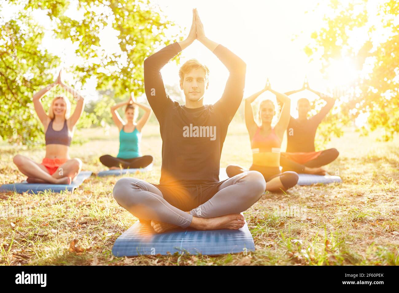 Relaxed group in yoga class in nature in the lotus position for ...
