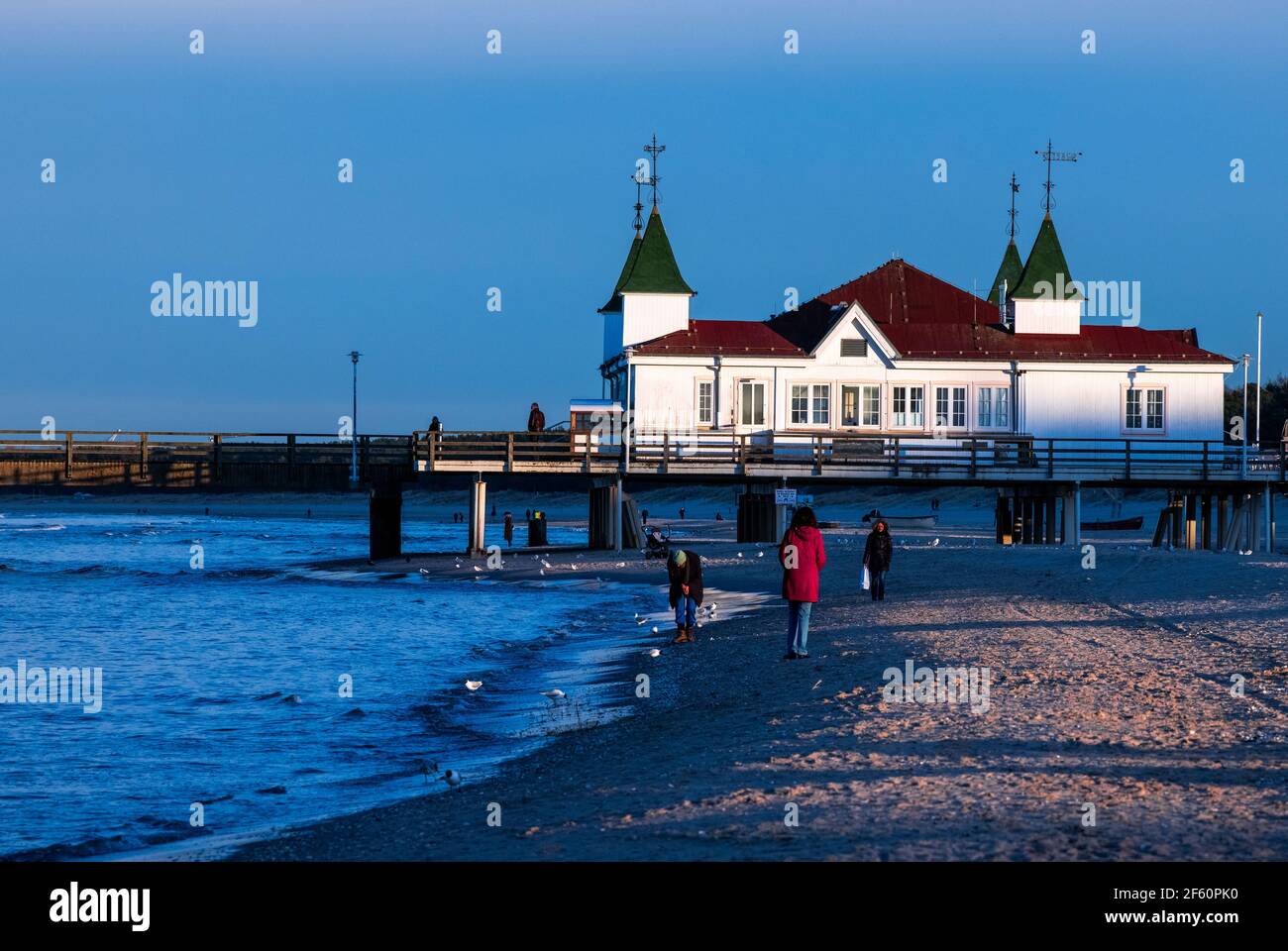 Ahlbeck, Germany. 22nd Mar, 2021. The pier is lit up orange-red on the ...