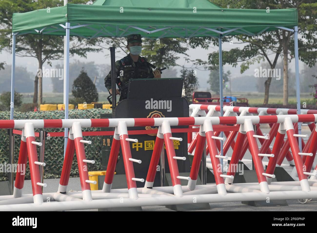 An armed police officer stands guard near a border post in Ruili, a ...