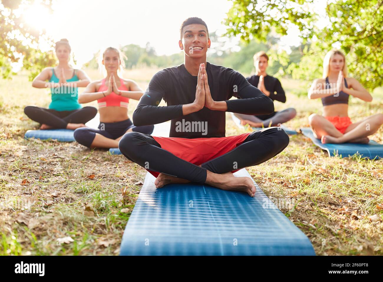 Group of friends having a yoga meditation in the lotus position in ...