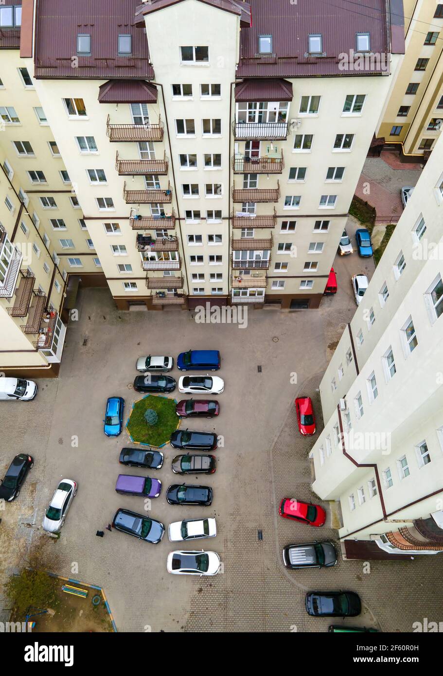 Aerial view of parked cars on parking lot between high apartment ...