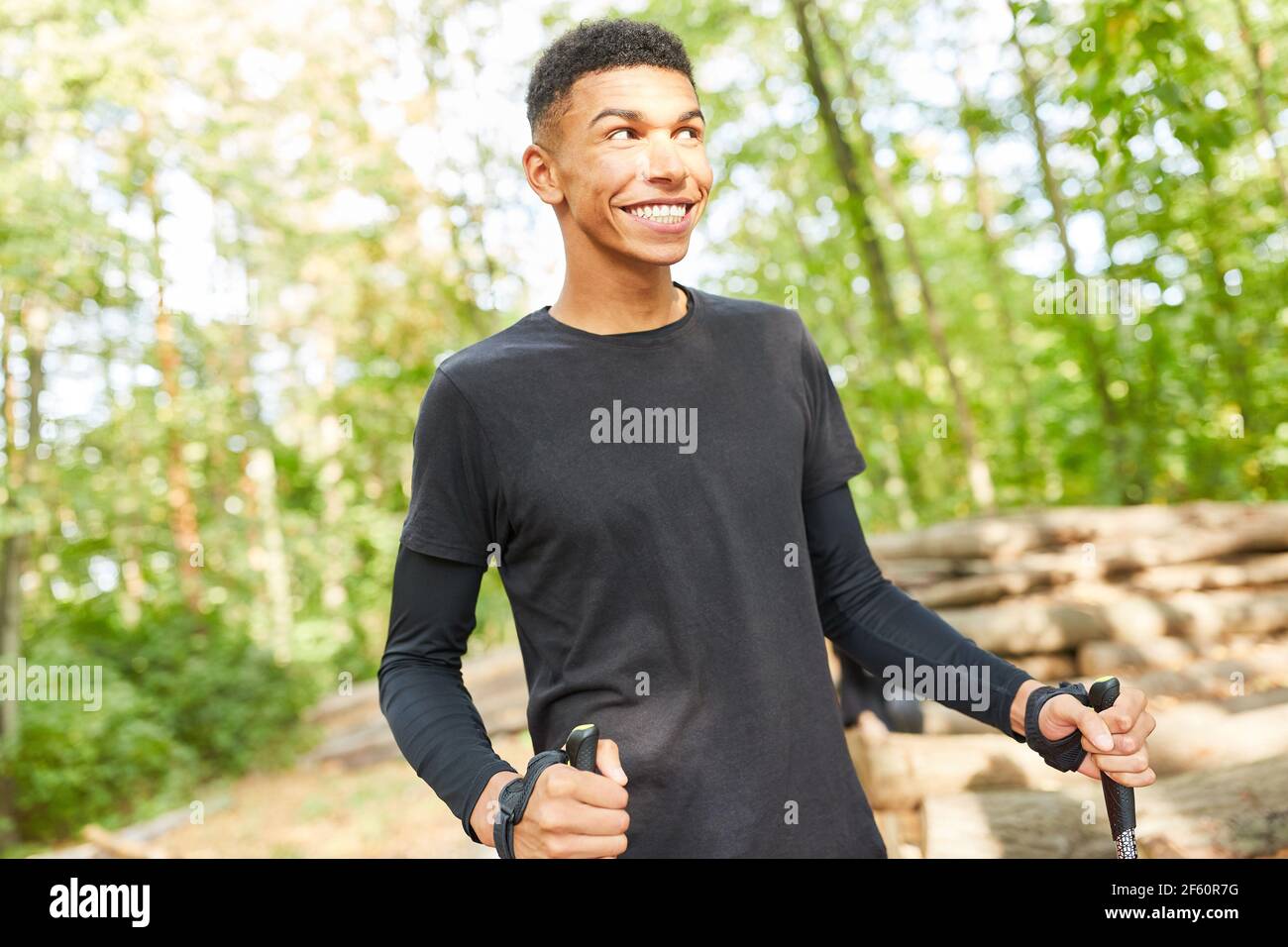 Sporty young man doing Nordic walking as fitness training in nature ...