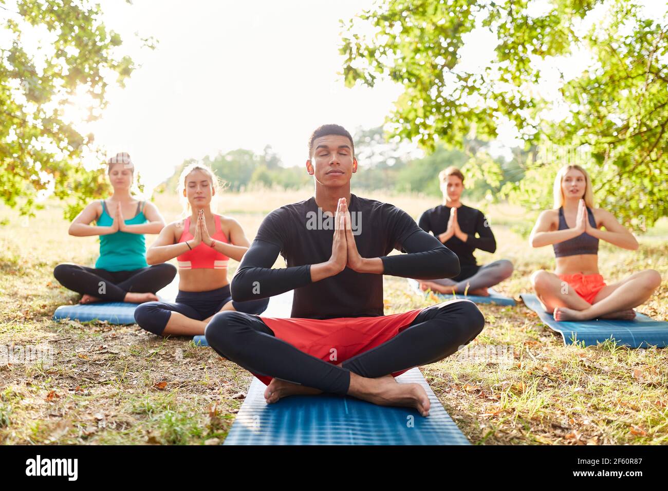 Group of young people enjoying a zen meditation in yoga class in the ...