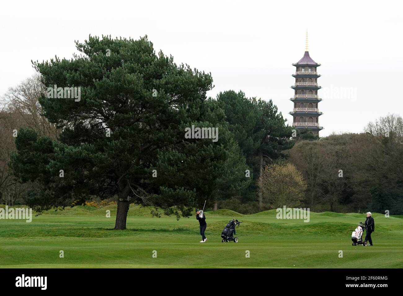 Jane O'Donnell (left) hits a fairway shot watched by Sara Geater ...