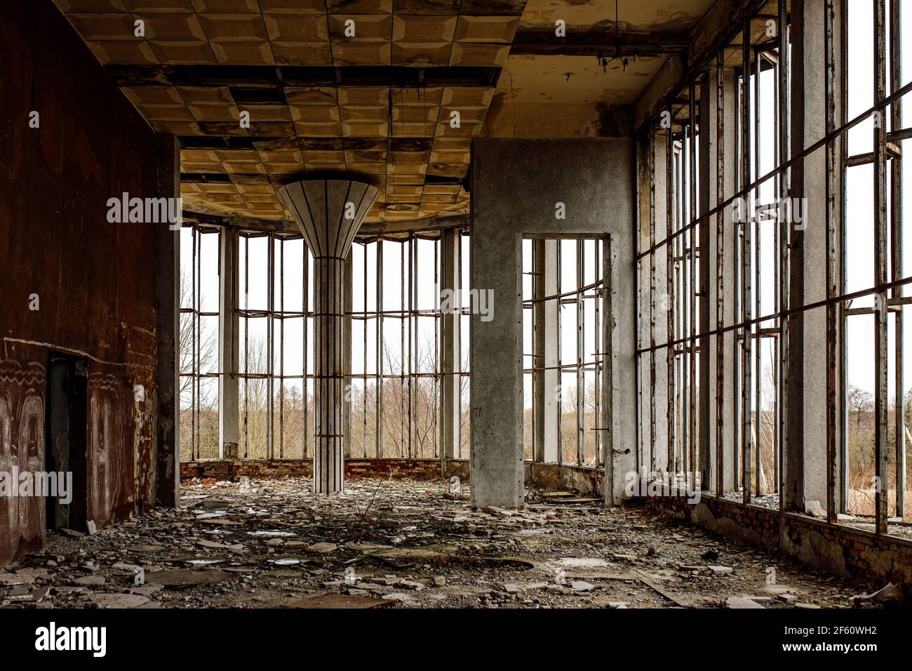 The ruined hall of an old building with wide windows. Broken glass on ...