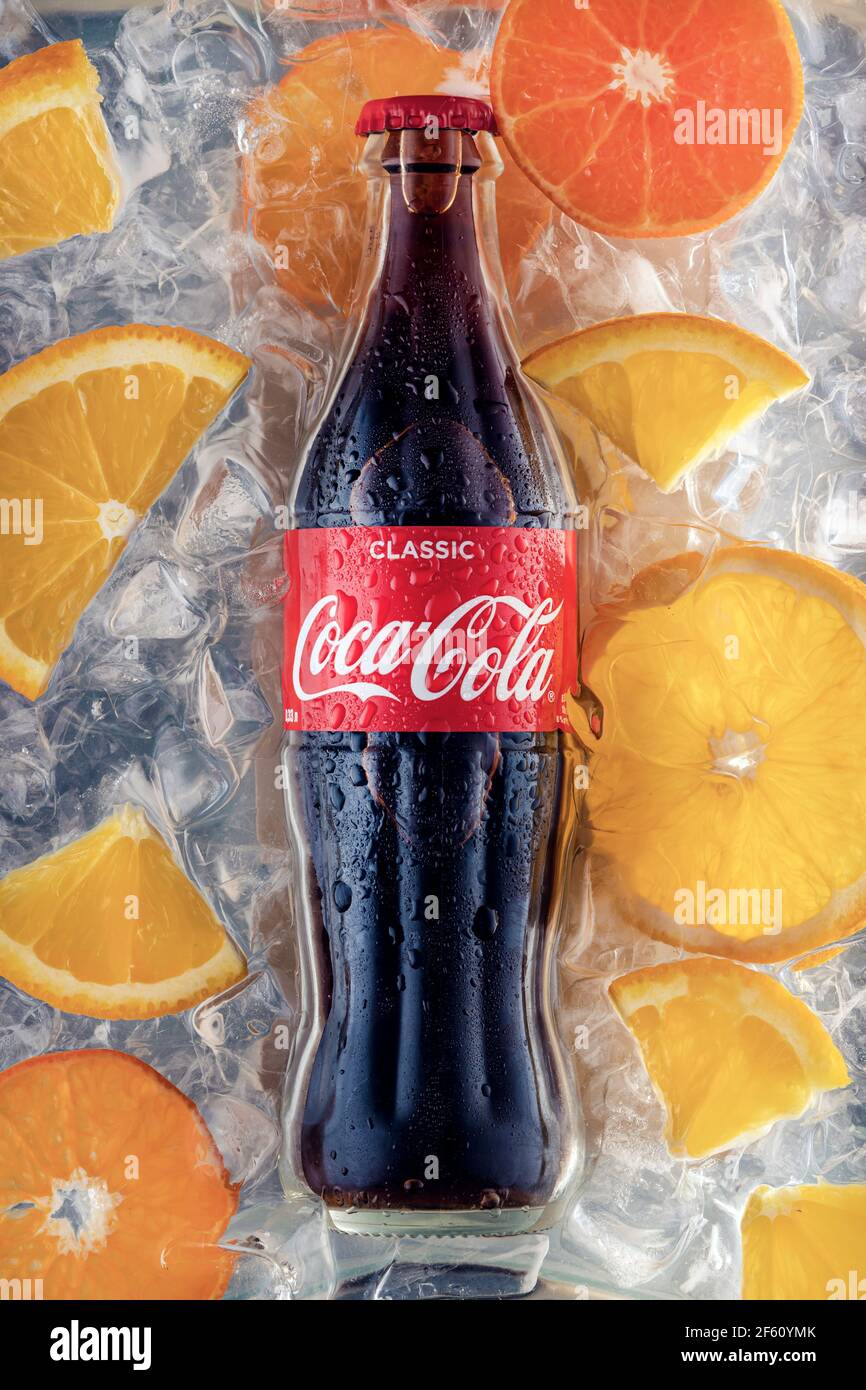 A bottle of Coca-Cola and slices of orange and citrus on the background ...