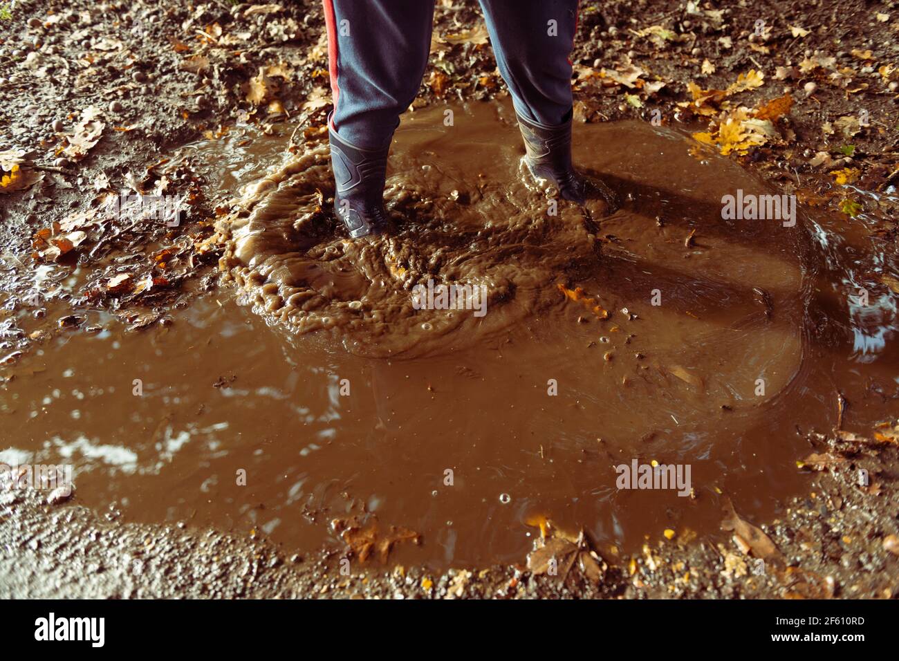Child splashing in muddy puddle Stock Photo - Alamy
