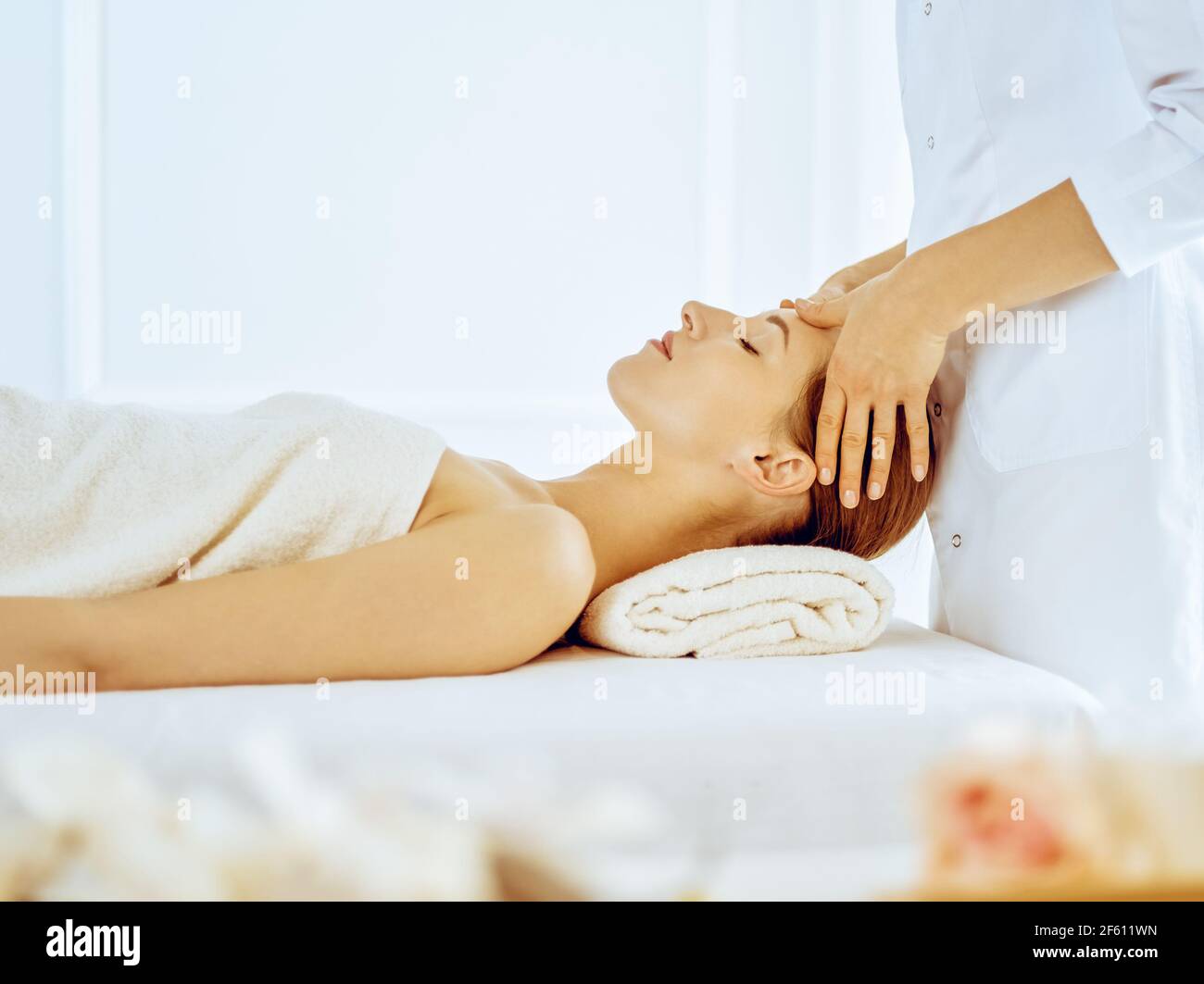 Beautiful woman enjoying facial massage with closed eyes in spa center ...
