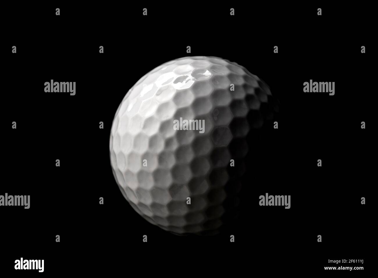 High contrast studio shot of golf ball isolated on black background ...