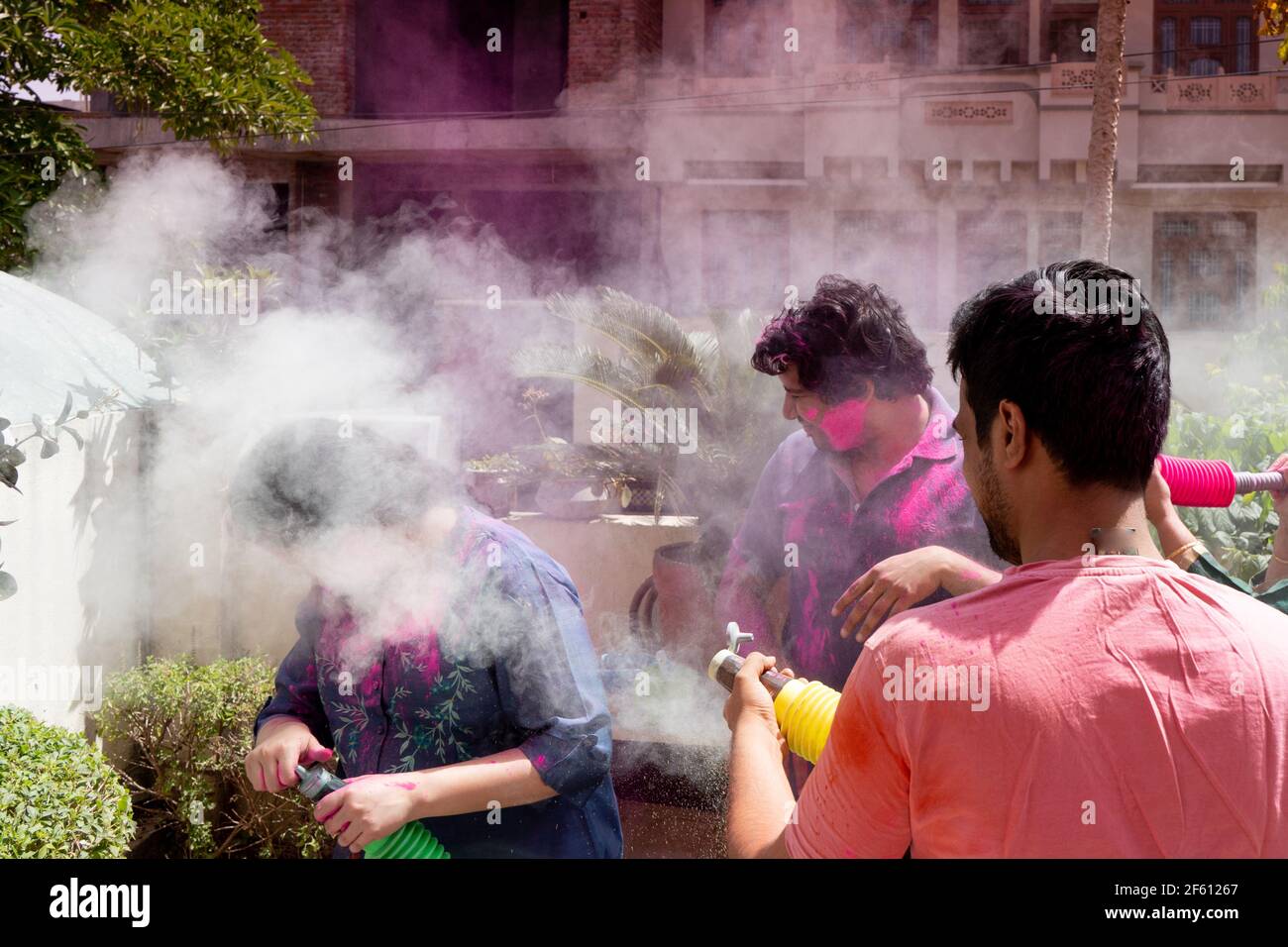 people, men women throwing colorful dust powder at each other on the ...
