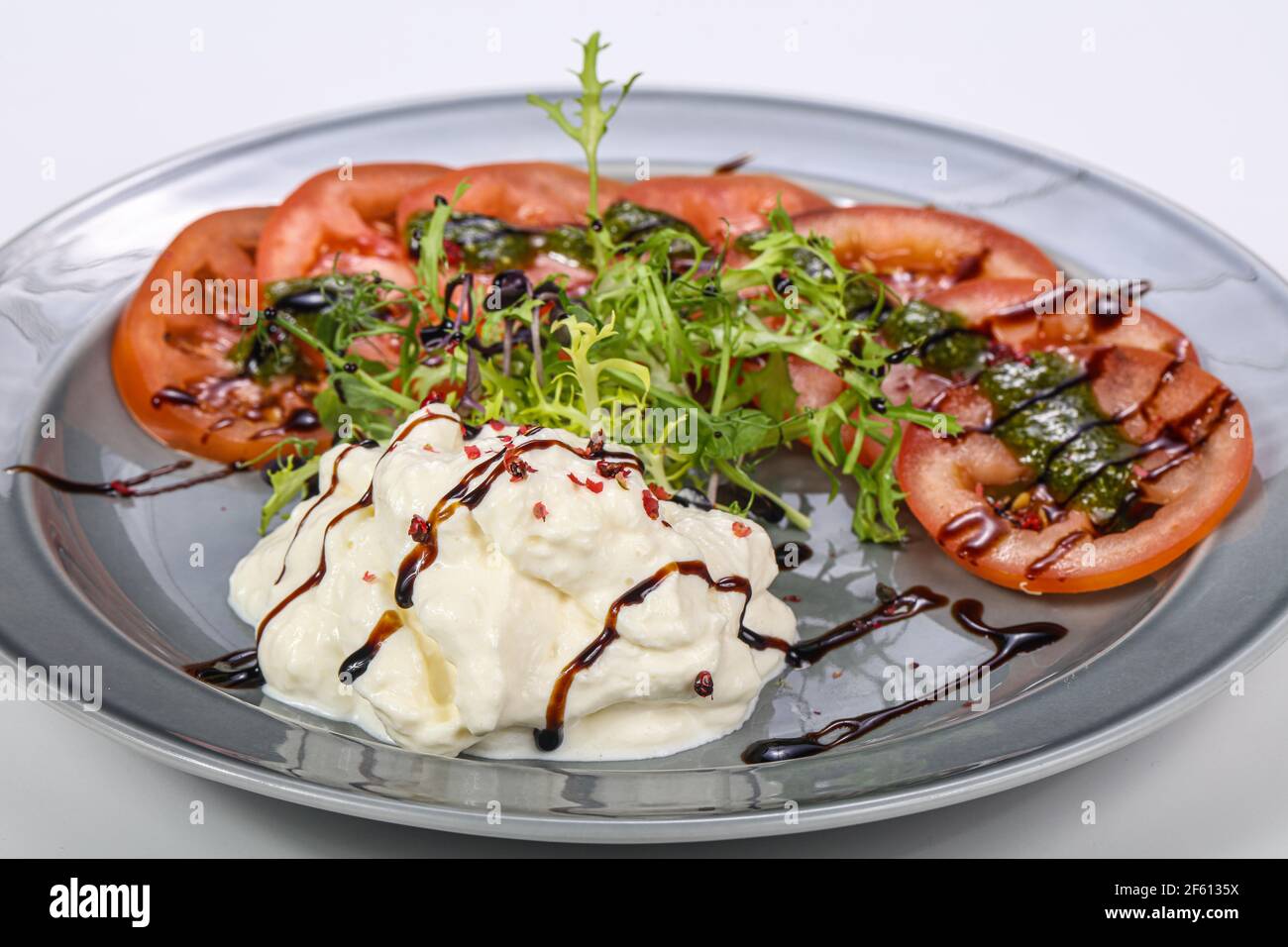 Strachatella cheese with tomato, balsamico and rucola Stock Photo - Alamy