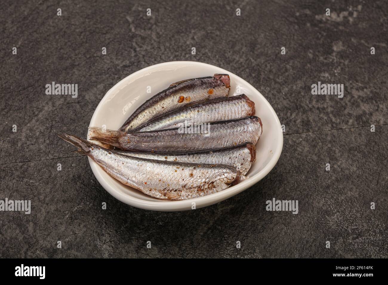 Anchovies fish snack in the bowl served basil leaves Stock Photo - Alamy