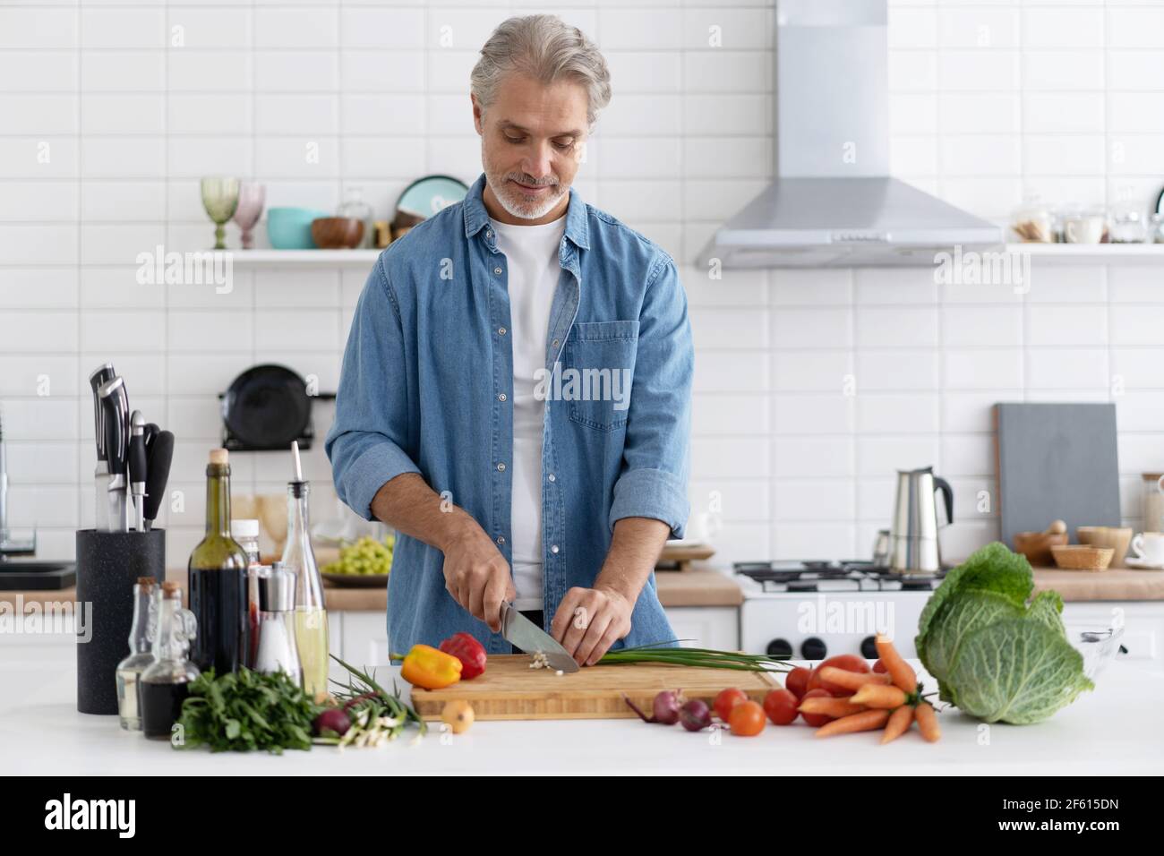 Happy handsome man cooking in kitchen at home Stock Photo - Alamy