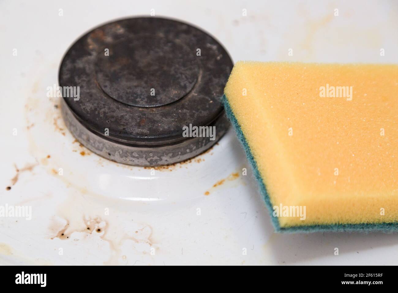 Cleaning sponge on the surface of a dirty gas stove Stock Photo - Alamy