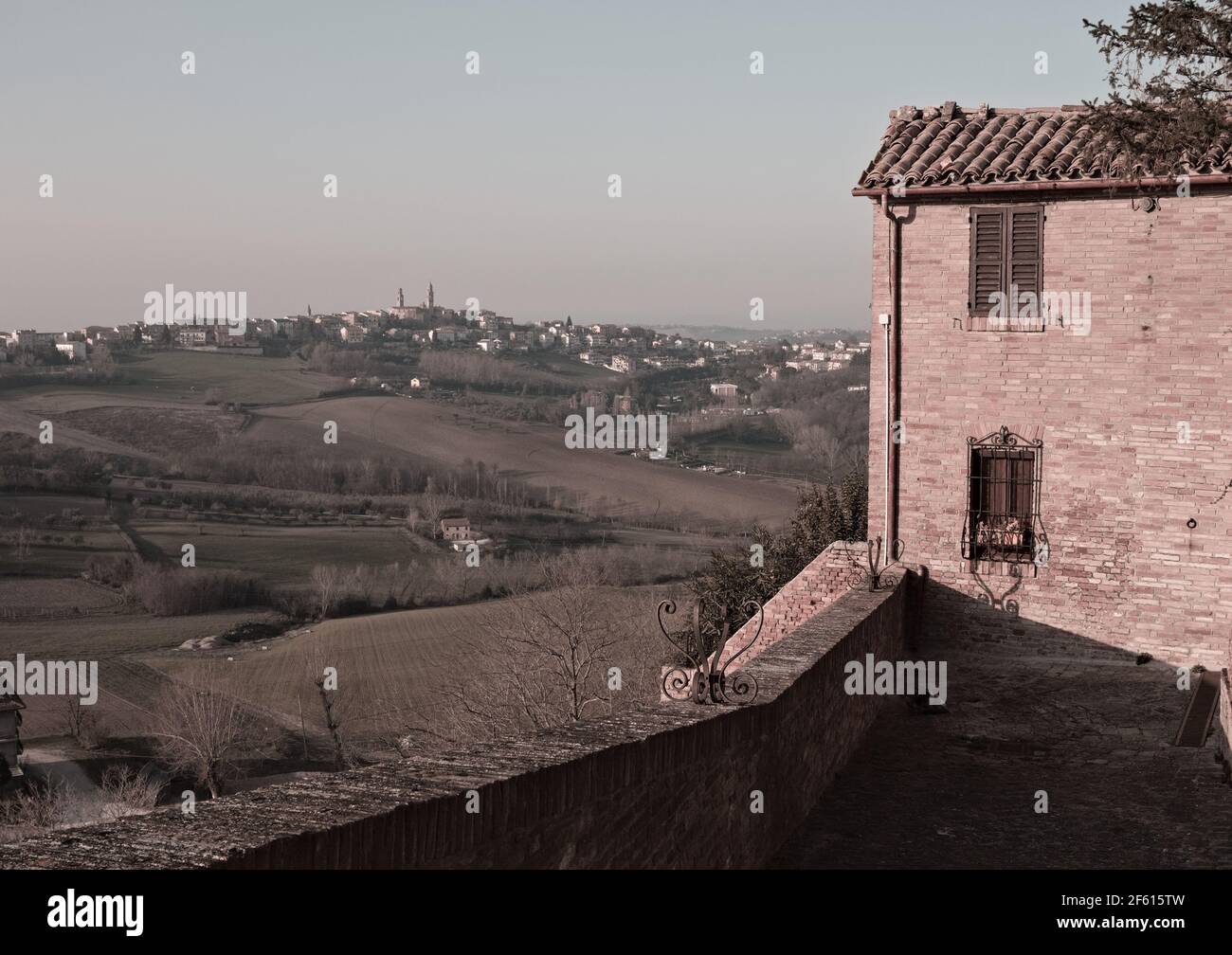 The walls of a medieval Italian village with brick buildings and a ...