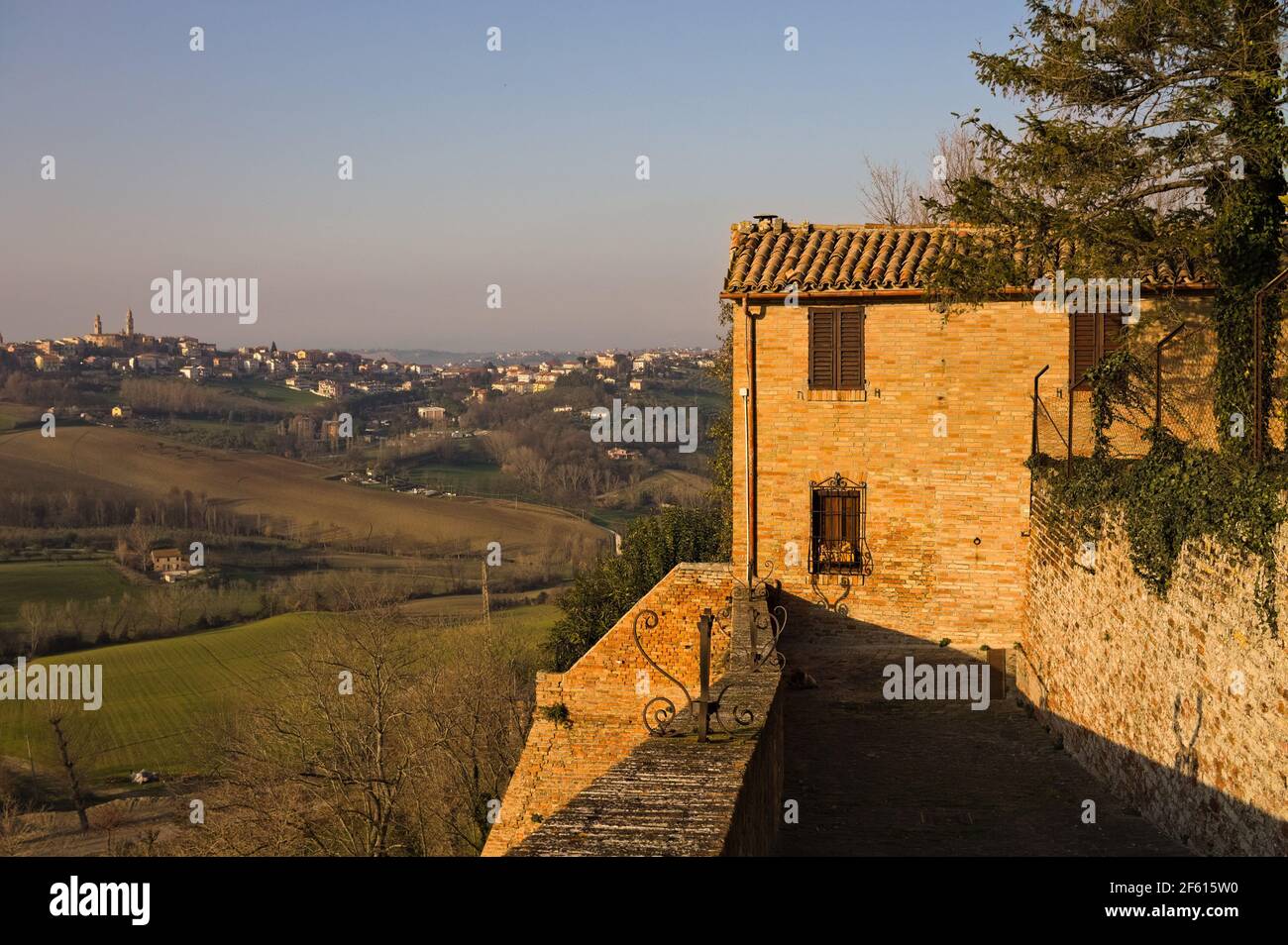 The walls of a medieval Italian village with brick buildings and a ...