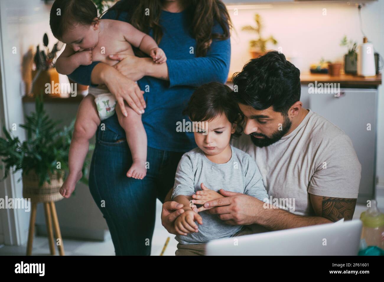 Children and parents taking online advice on video call through laptop ...