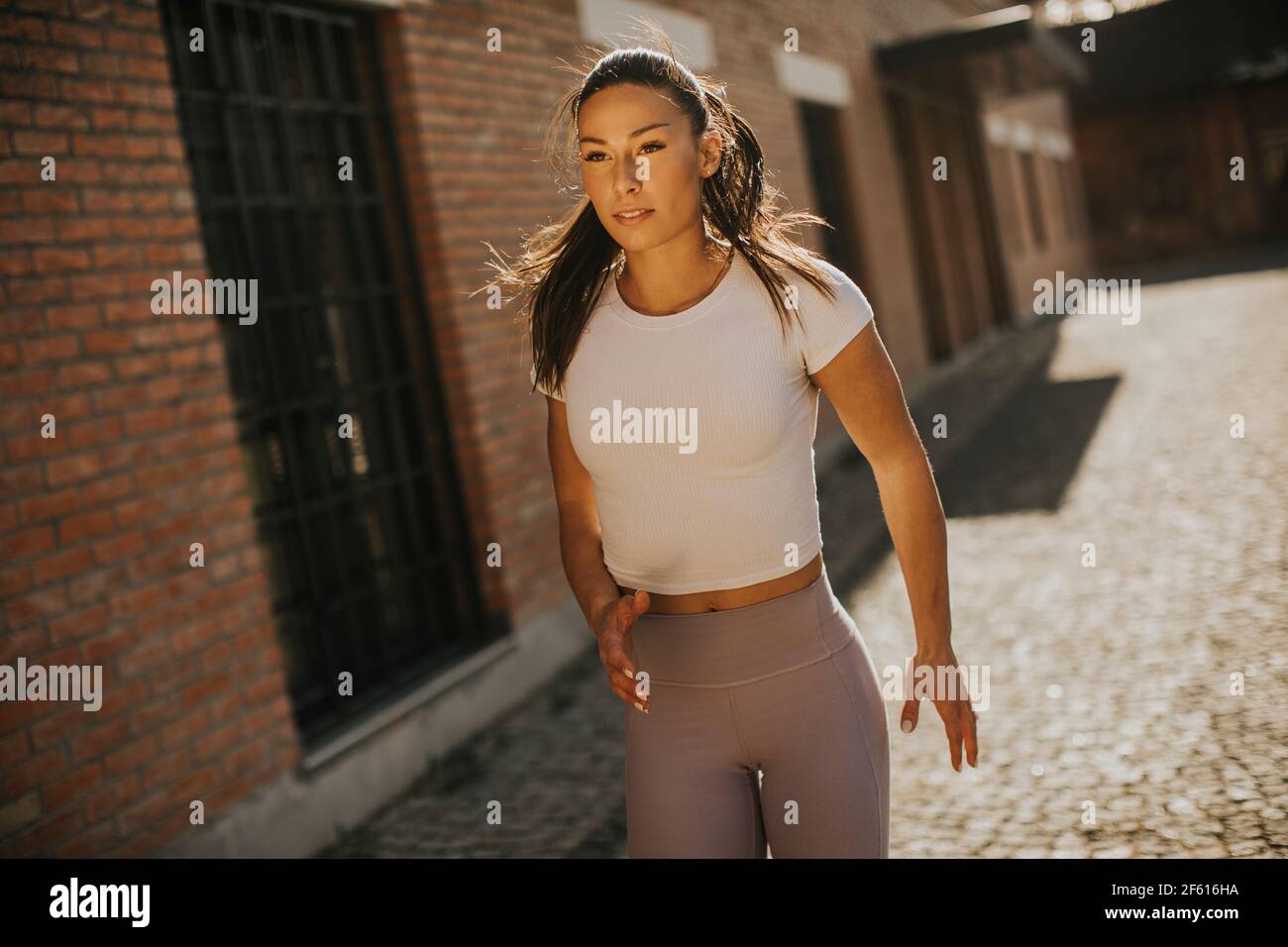 Pretty young woman running on the street Stock Photo - Alamy