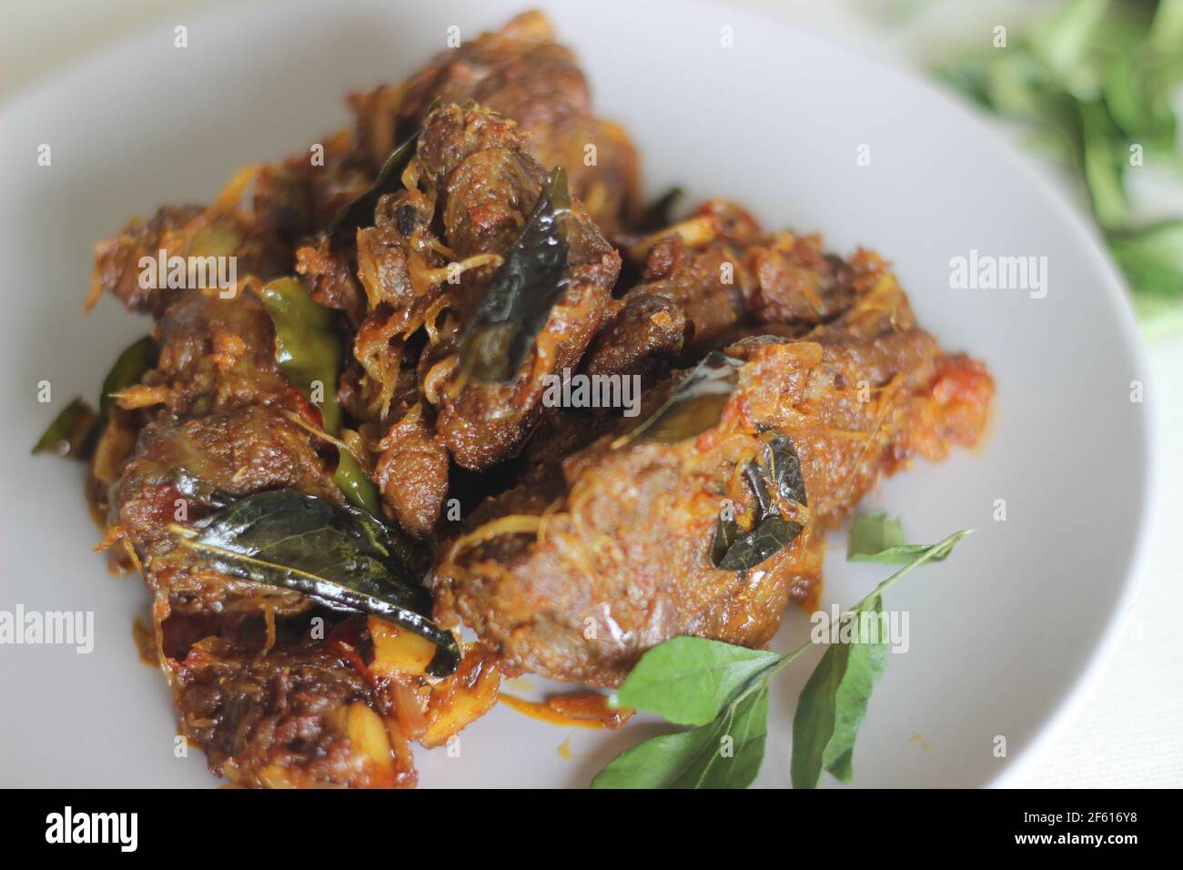 Kerala style mutton roast prepared with coconut oil. Shot on white ...