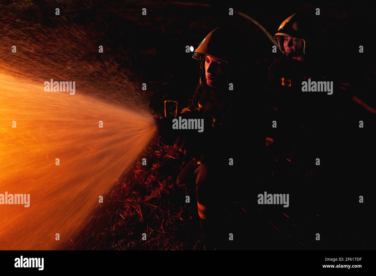 Professional firefighters puttion out a fire with water Stock Photo - Alamy