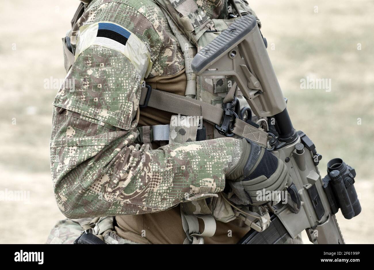 Soldier with assault rifle and flag of Estonia on military uniform ...