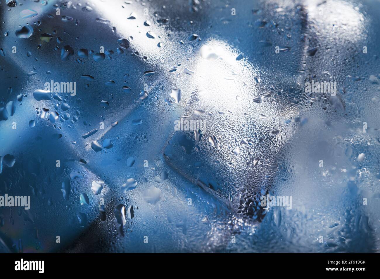 Ice cubes in a misted glass with drops of ice water close-up macro. Refreshing and chilling ...
