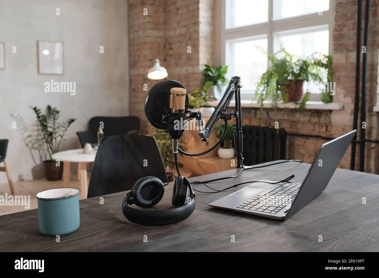 Image of workplace with laptop microphone and headphones in modern ...