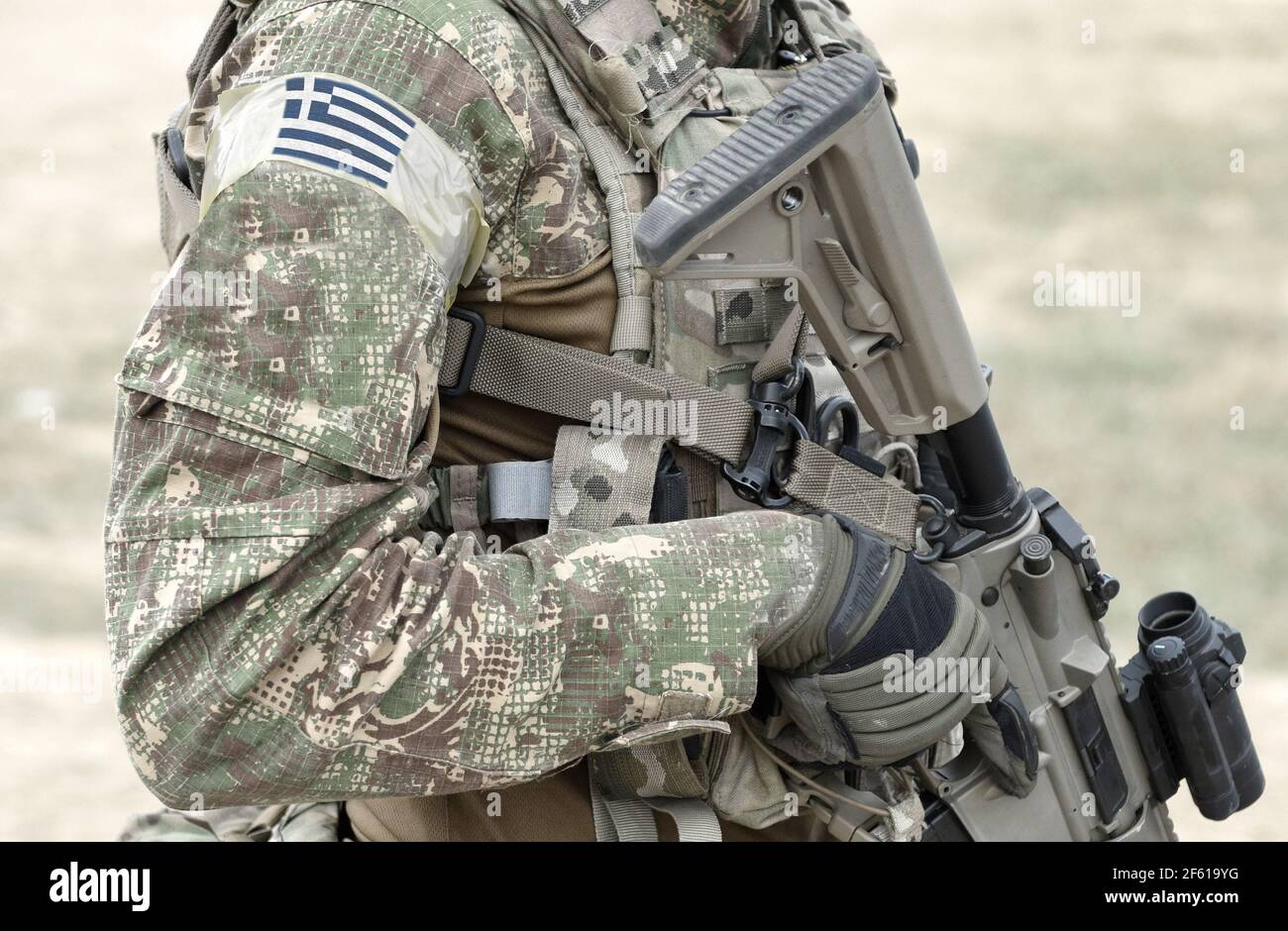 Soldier with assault rifle and flag of Greece on military uniform ...
