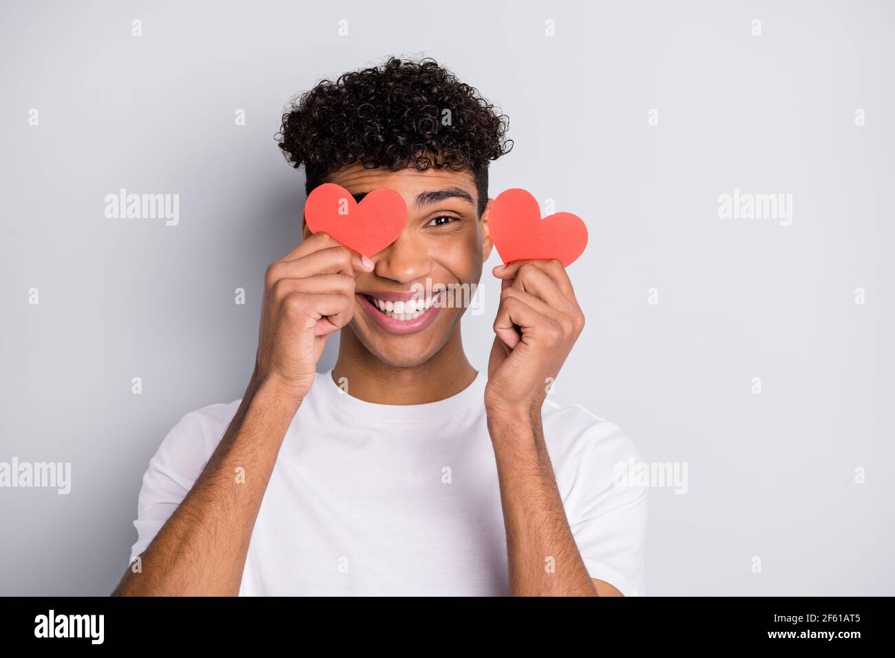 Photo of brunet optimistic curly funky guy cover eyes by hearts wear ...