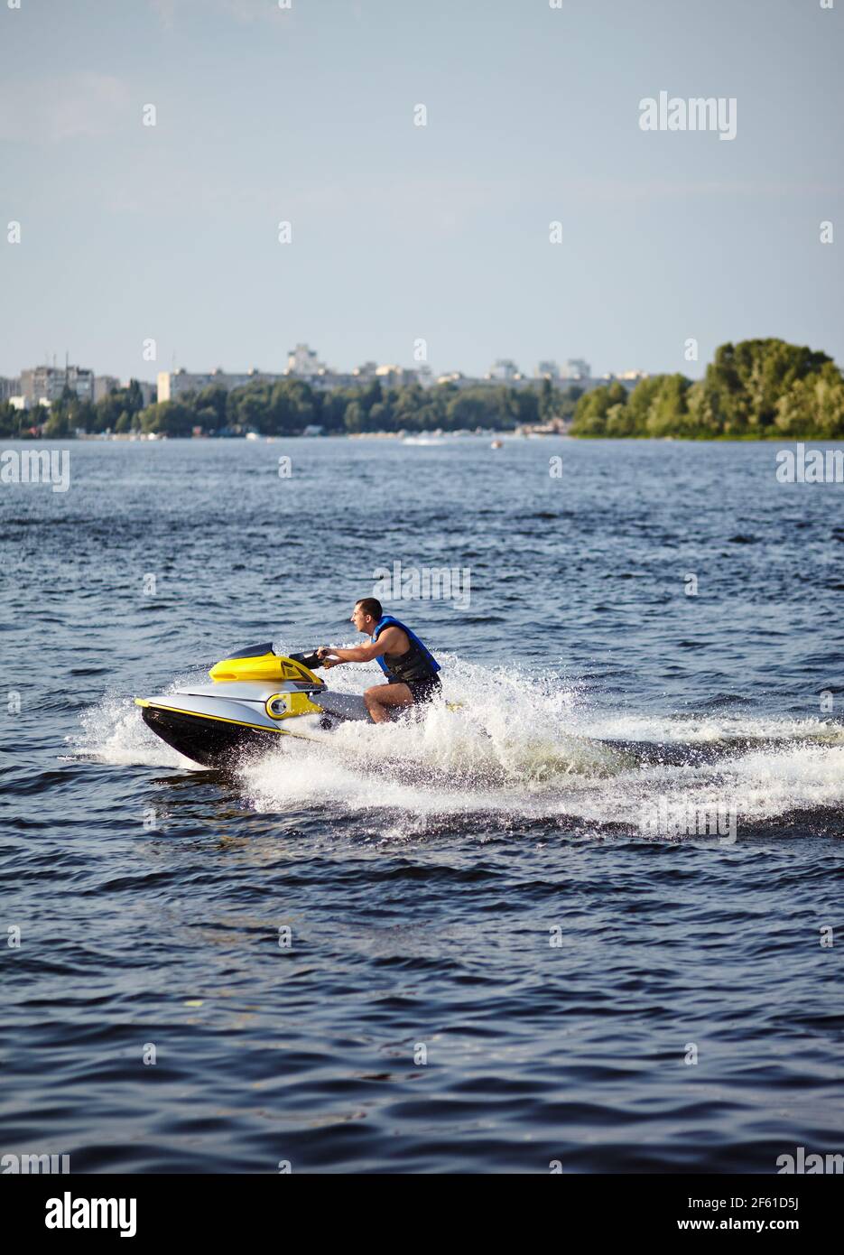Strong man jumps on the jetski above the water. Man speeding on jet ski ...