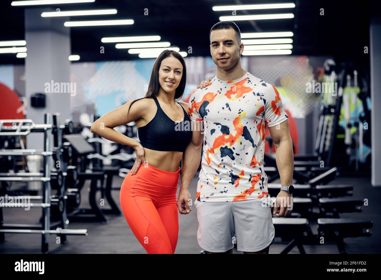 Happy muscular couple standing in gym and posing. Healthy lifestyle ...
