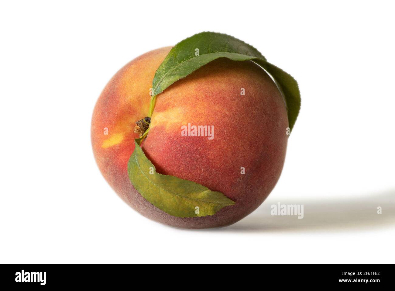 A ripe peach with leaves on white background sideways, whole, fruit ...