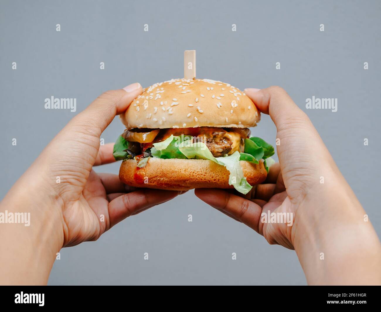 Delicious fresh homemade burger. hands holding tasty homemade hamburger ...