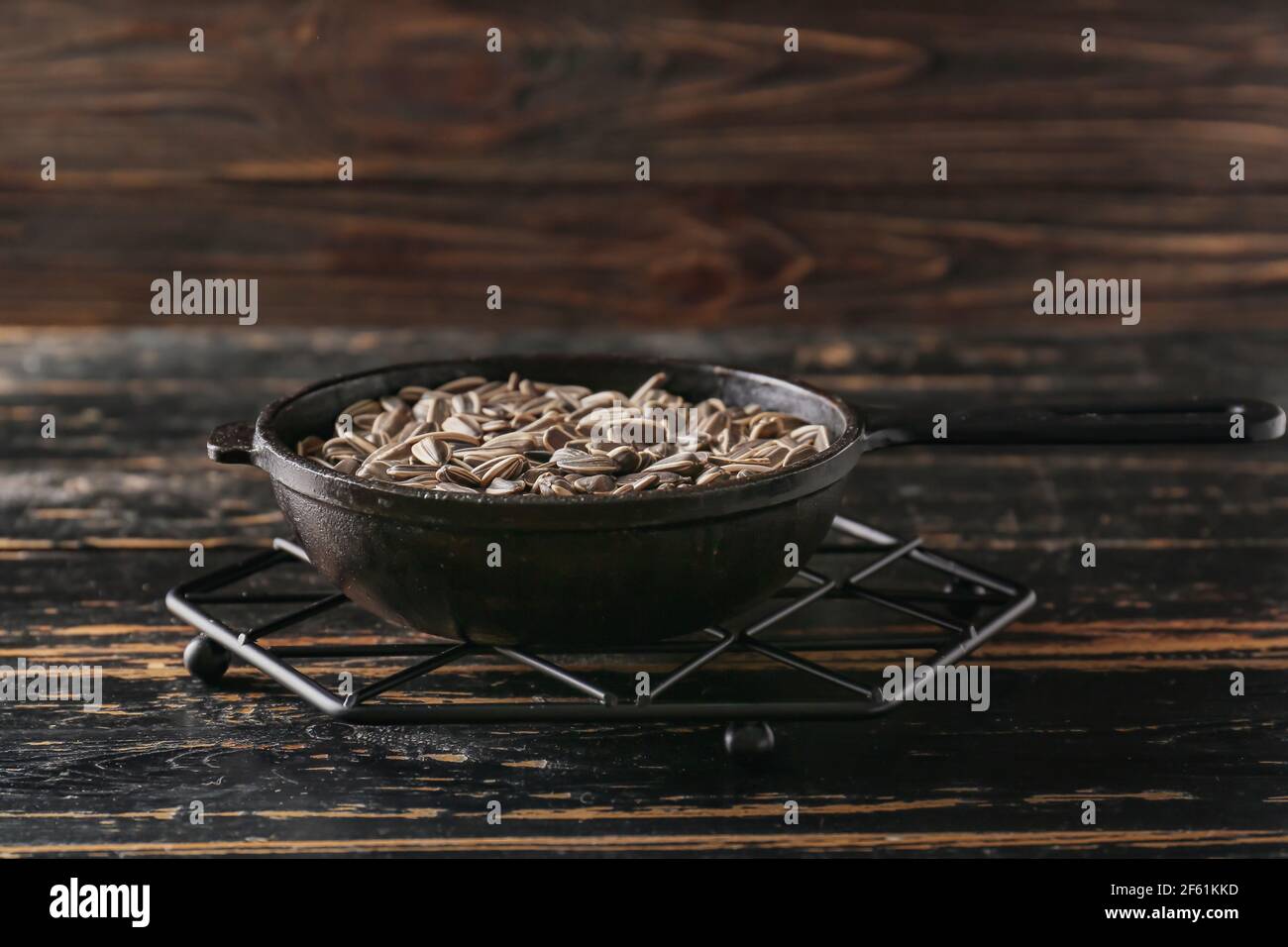 Frying pan with sunflower seeds on dark wooden background Stock Photo ...