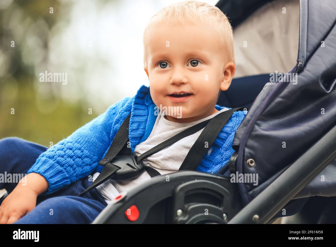 Cute funny baby in stroller outdoors Stock Photo - Alamy