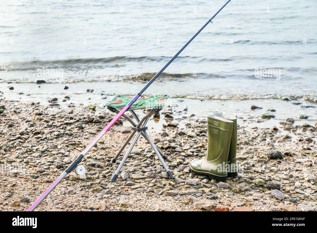 Equipment of fisherman on river bank Stock Photo - Alamy
