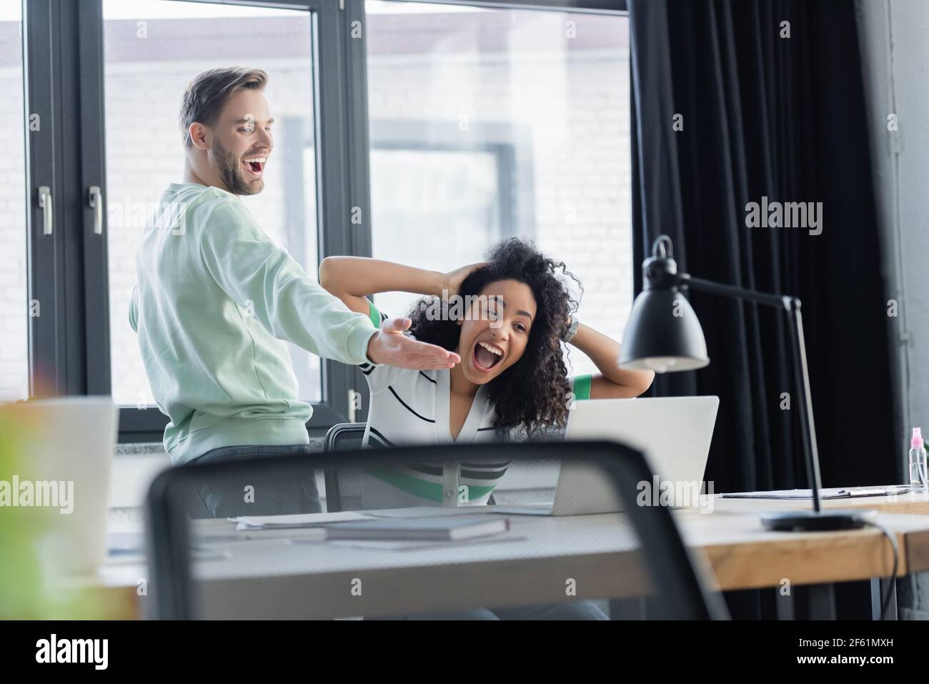 excited manager pointing with hand near thrilled african american ...