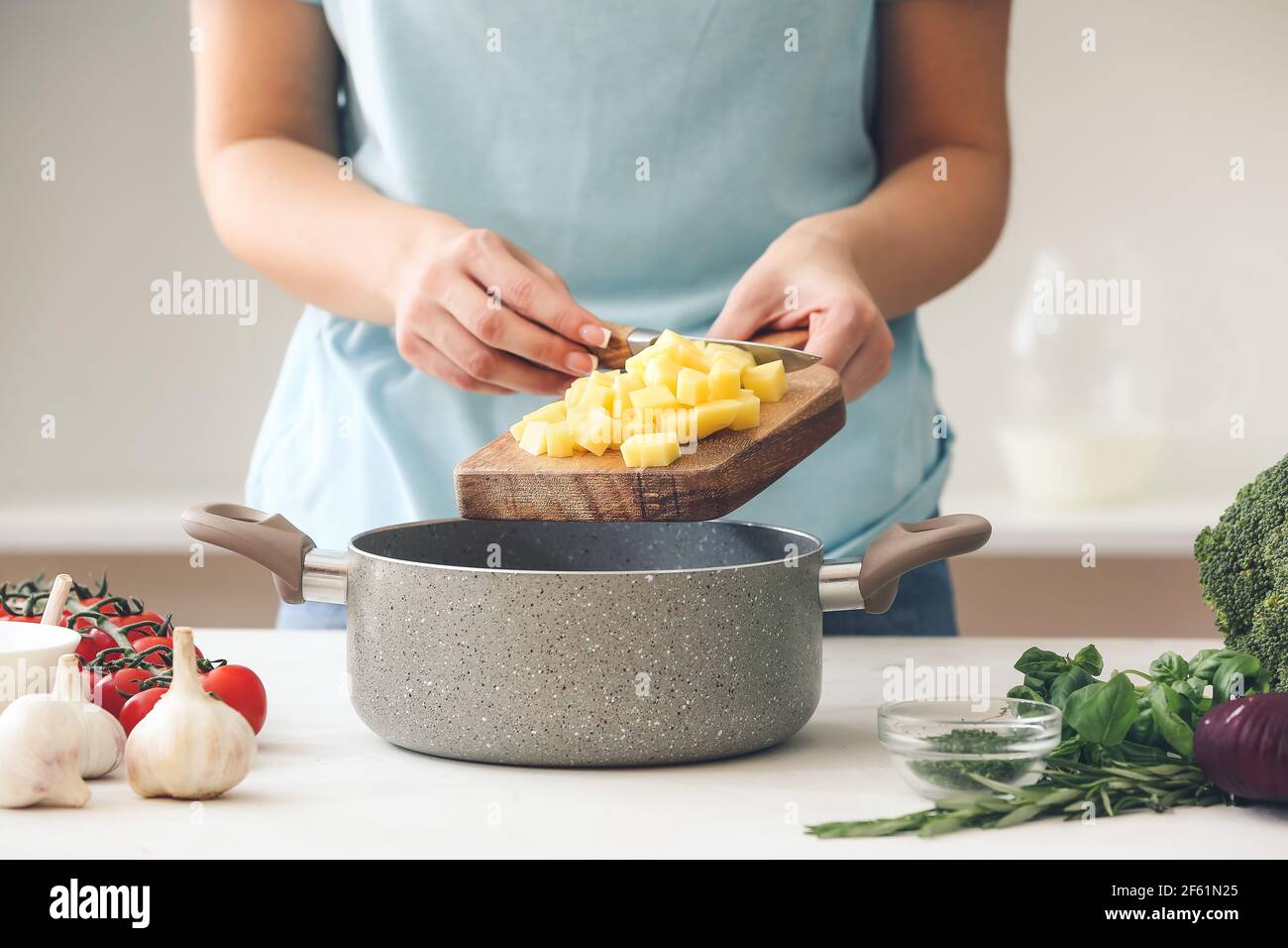 Woman putting garlic in pot hi-res stock photography and images - Alamy