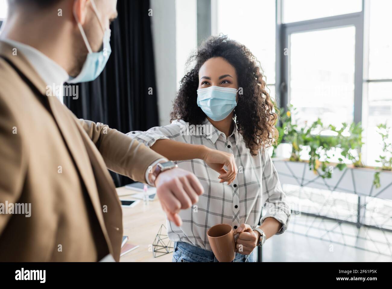 african american businesswoman doing elbow bump with colleague on ...