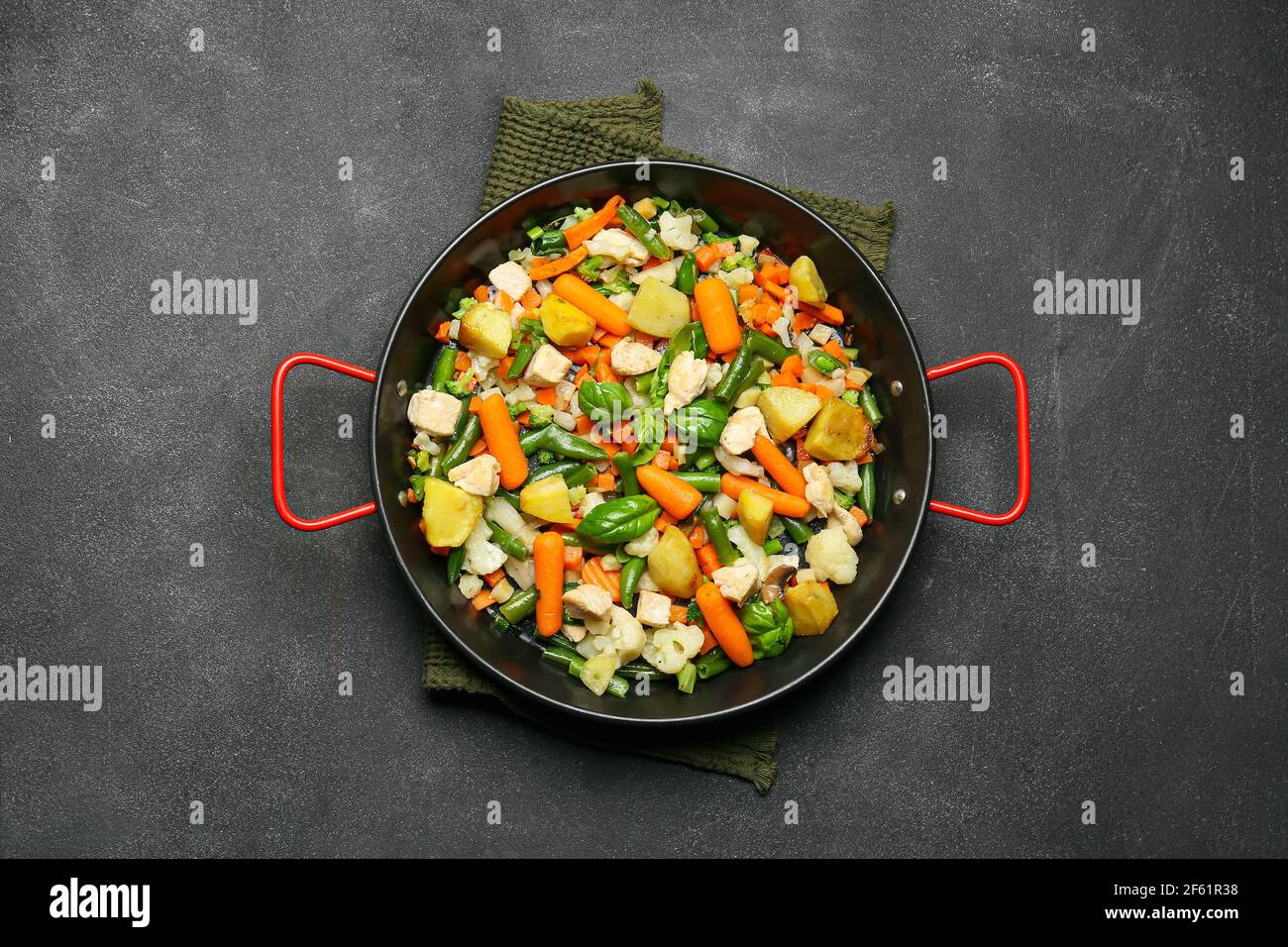 Frying pan with tasty vegetables and chicken on dark background Stock ...