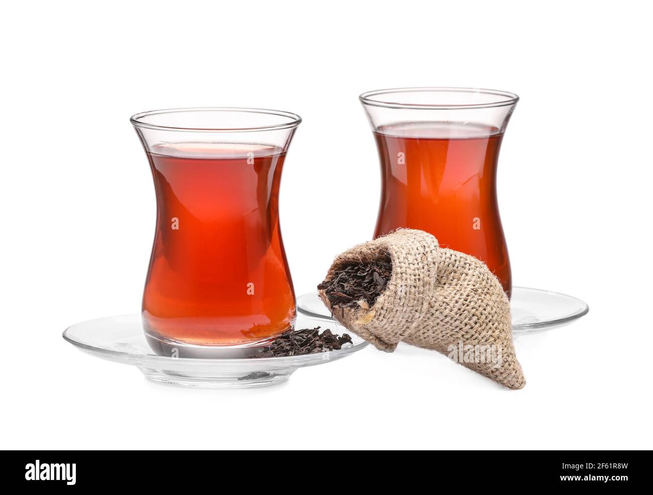 Glasses of tasty Turkish tea and bag with dry leaves on white ...