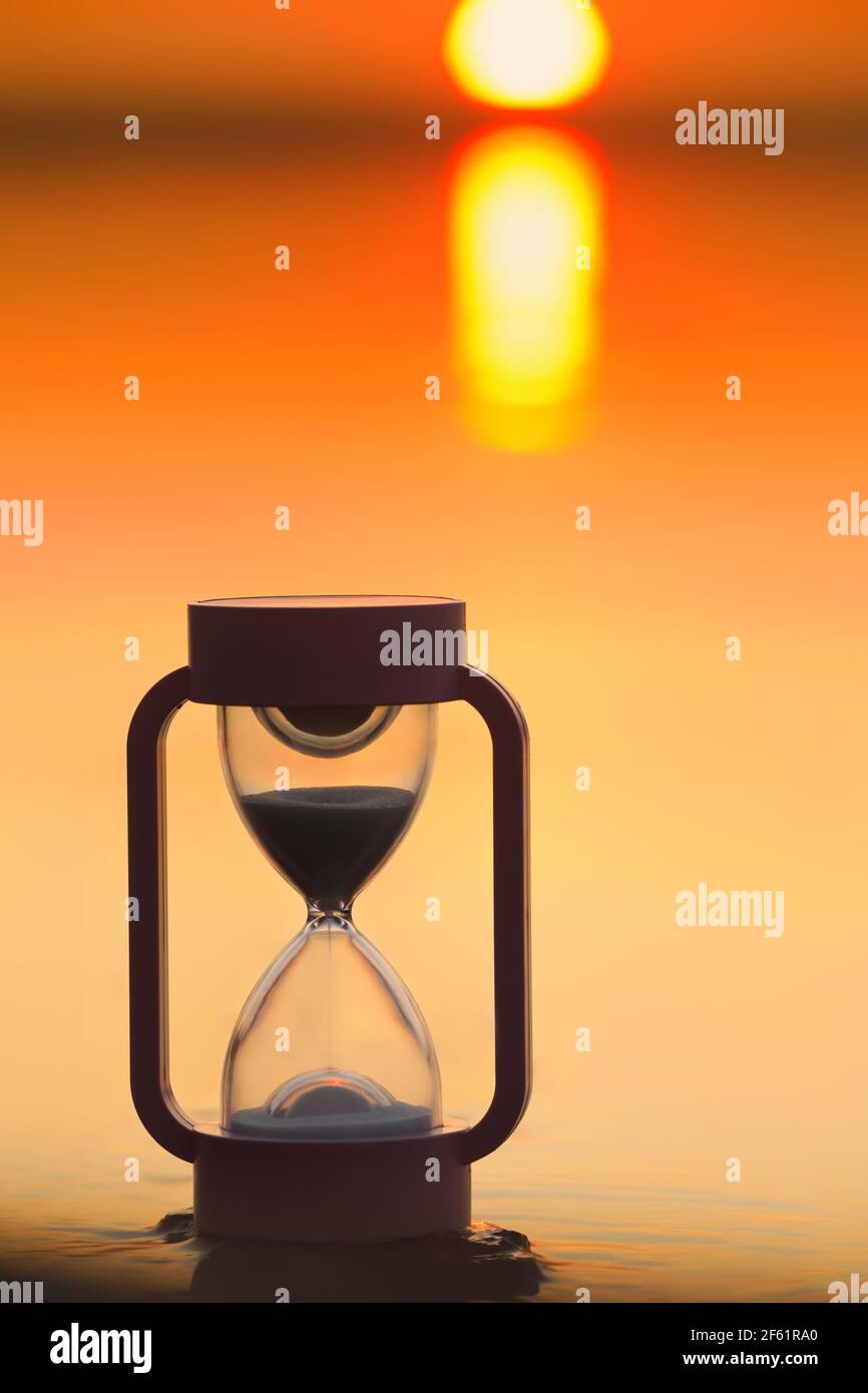 Stylish hourglass on sand near river outdoors Stock Photo - Alamy