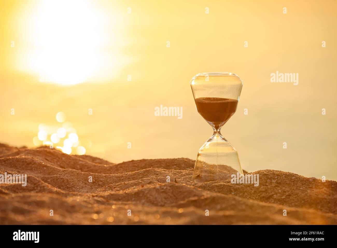 Stylish hourglass on sand near river outdoors Stock Photo - Alamy