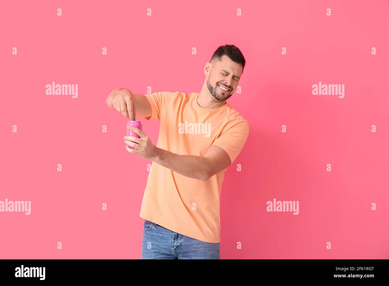 Handsome man opening can of soda on color background Stock Photo - Alamy