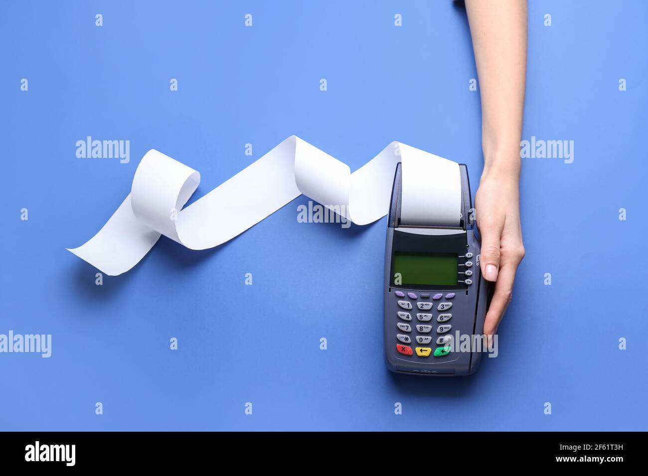 Female hand with payment terminal on color background Stock Photo - Alamy