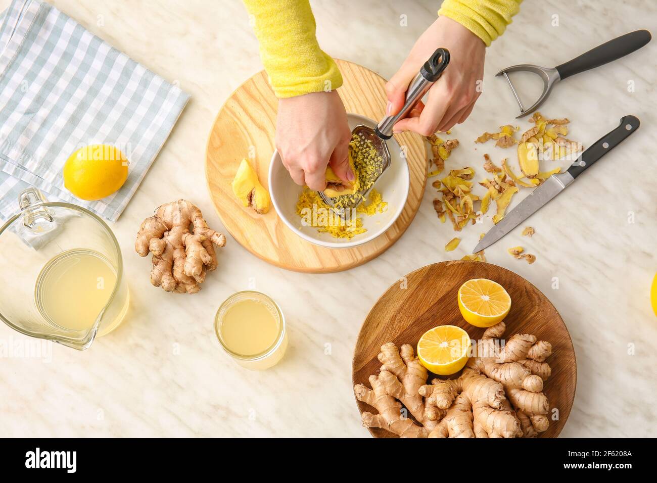 Woman grating ginger on light background Stock Photo - Alamy